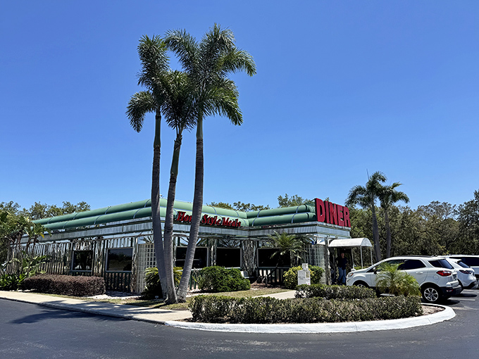 The classic stainless steel exterior of Sebring Diner gleams under the Florida sun like a time machine disguised as a restaurant. Those palm trees aren't just decoration—they're sentinels guarding a temple of comfort food.