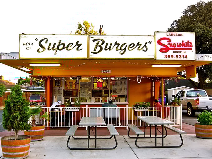 The classic red and white facade of Snowhite Drive In promises what every roadside dreamer hopes for—honest food with zero pretension.
