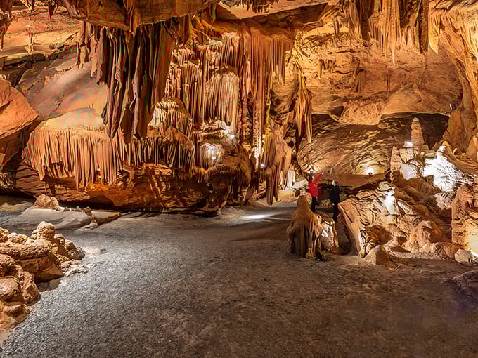 Nature's own art gallery unfolds before you, with amber-hued stalactites hanging like prehistoric chandeliers in this underground wonderland.