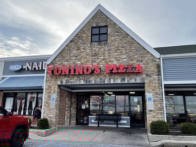 The stone facade of Tonino's Pizza stands like a culinary lighthouse on Jonestown Road, beckoning hungry travelers with its bold red signage.