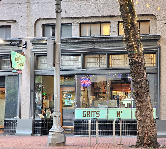 The turquoise storefront glows at dusk, with twinkling lights wrapped around a nearby tree – Portland's version of a Southern welcome beacon.