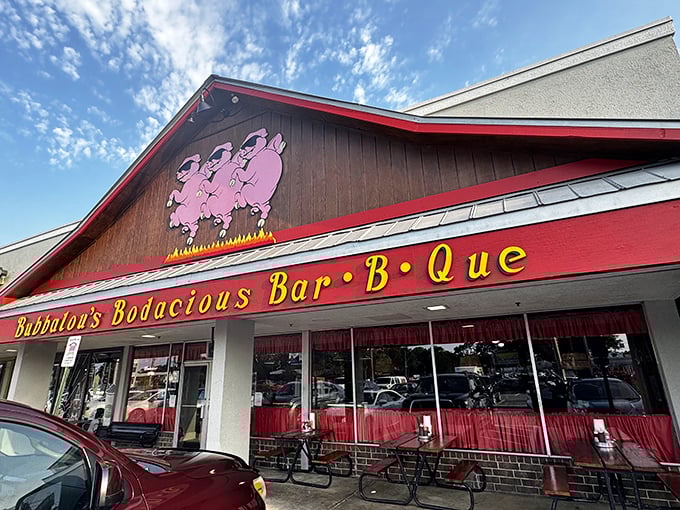 Those dancing pink pigs on the sign aren't just cute mascots—they're a promise of the smoky delights waiting inside Bubbalou's wood-paneled sanctuary.