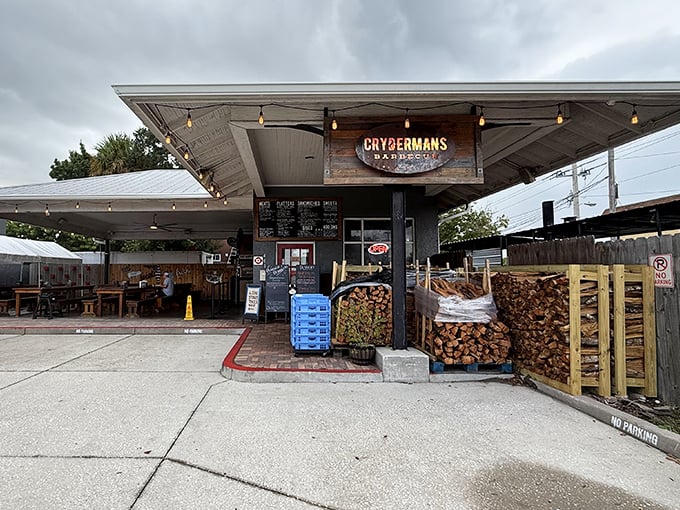 Stacks of oak firewood stand ready for their smoky sacrifice, the secret behind that bark-crusted brisket that keeps locals coming back. String lights add just enough charm without getting fancy about it.