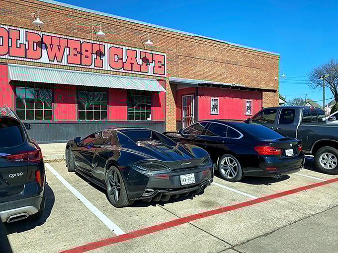 The brick exterior with bold red signage might not scream "culinary destination," but those luxury cars in the parking lot? They know something you don't.