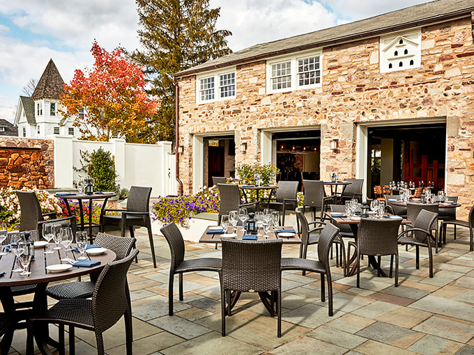 Stone walls that have witnessed centuries of celebrations frame the elegant outdoor dining area, where autumn colors provide nature's perfect backdrop.