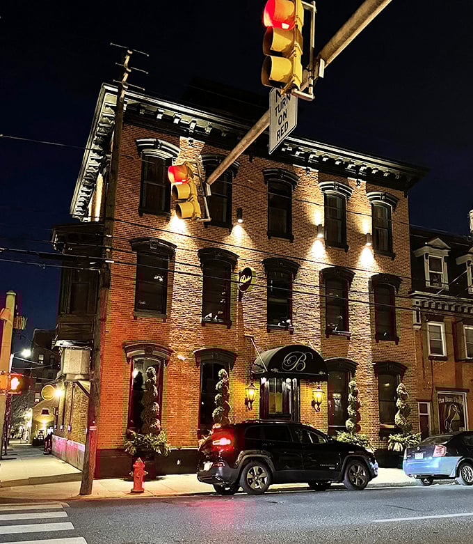 The Belvedere Inn glows like a Victorian beacon at night, its brick façade illuminated to welcome hungry Lancaster diners.
