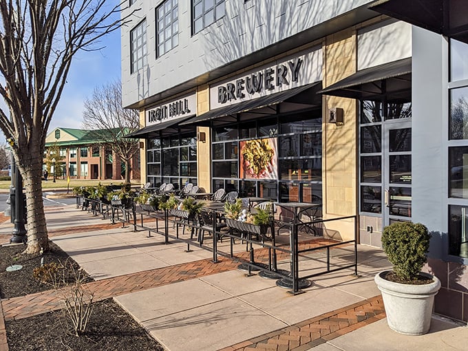 The modern façade of Iron Hill beckons with its inviting patio, promising craft beer nirvana and burger bliss just steps from Lancaster's bustling streets.