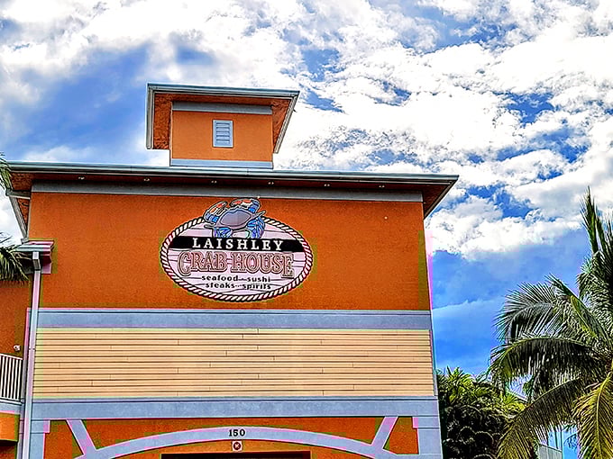 The peachy-orange exterior of Laishley Crab House stands like a beacon for hungry seafood lovers, promising Florida flavors with a side of harbor views.