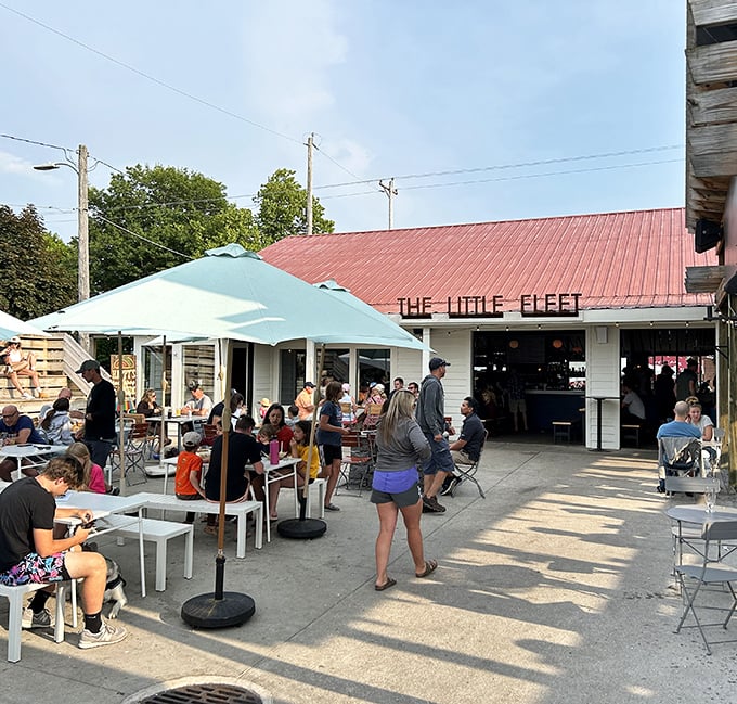The bustling patio at The Little Fleet proves that great food needs no fancy trappings—just aqua umbrellas, hungry patrons, and Michigan summer sunshine.