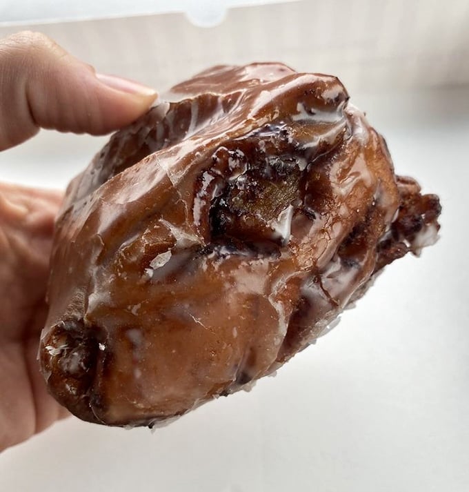 The apple fritter – that magnificent, misshapen marvel where apple chunks hide in glazed nooks and crannies like sweet buried treasure.