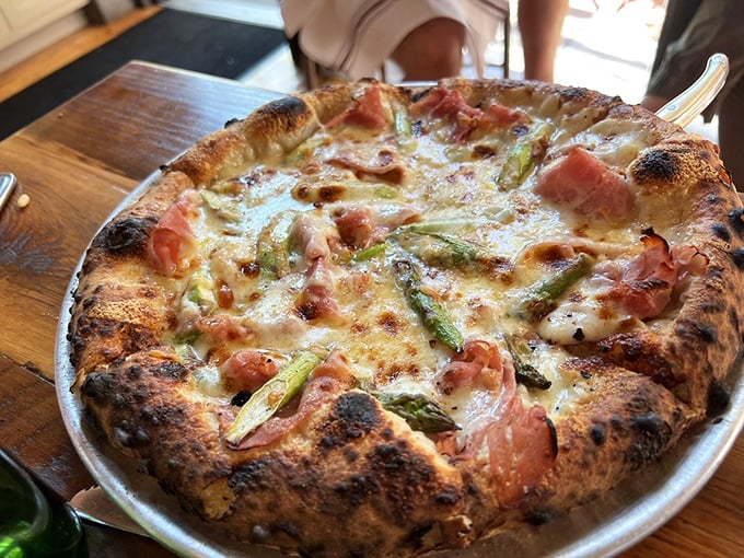 Prosciutto and asparagus pizza where the char on the crust plays perfect counterpoint to the delicate toppings—a study in delicious contrasts.