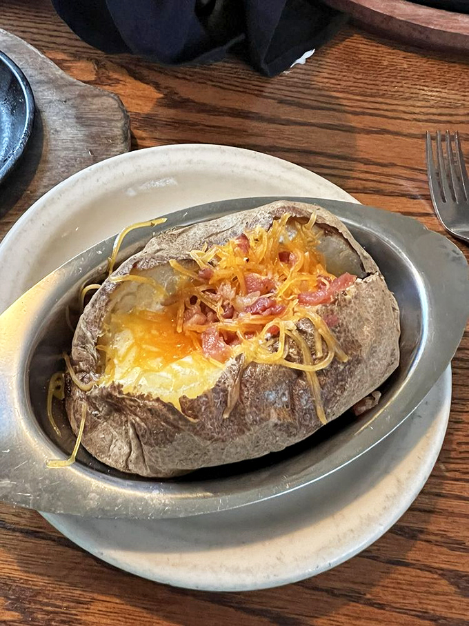 This loaded baked potato isn't just a side dish—it's a main event wrapped in foil, waiting to steal the spotlight from whatever it accompanies.