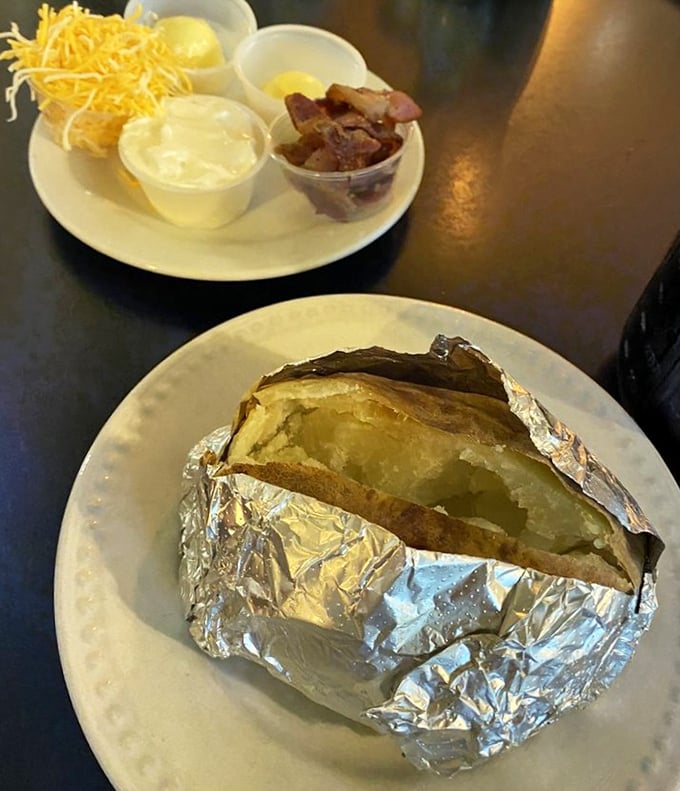 This baked potato, wrapped like a precious gift, sits ready to reveal its steamy, fluffy interior – the present you give yourself.
