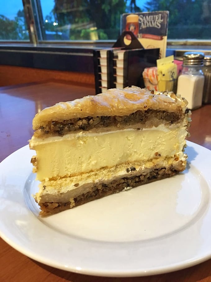 A slice of baklava cheesecake that's having an identity crisis in the most delicious way possible – honey, nuts, and creamy decadence.