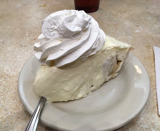 Banana cream pie wearing a cloud of whipped cream—proof that sometimes the most unforgettable desserts come on ordinary white plates.
