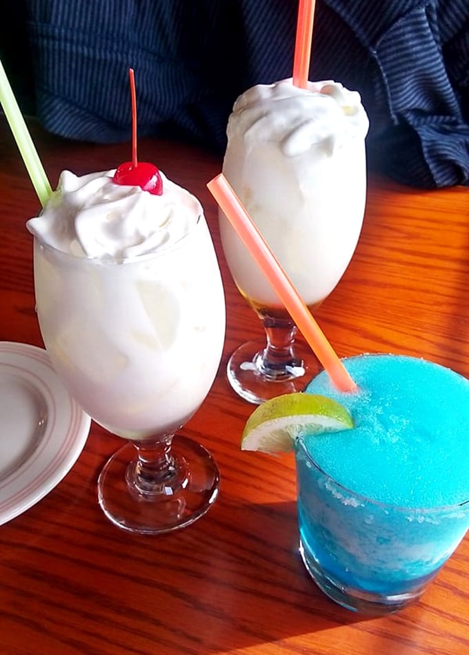 These drinks aren't just beverages—they're liquid intermissions between bites of beef. That blue margarita is practically winking at you.