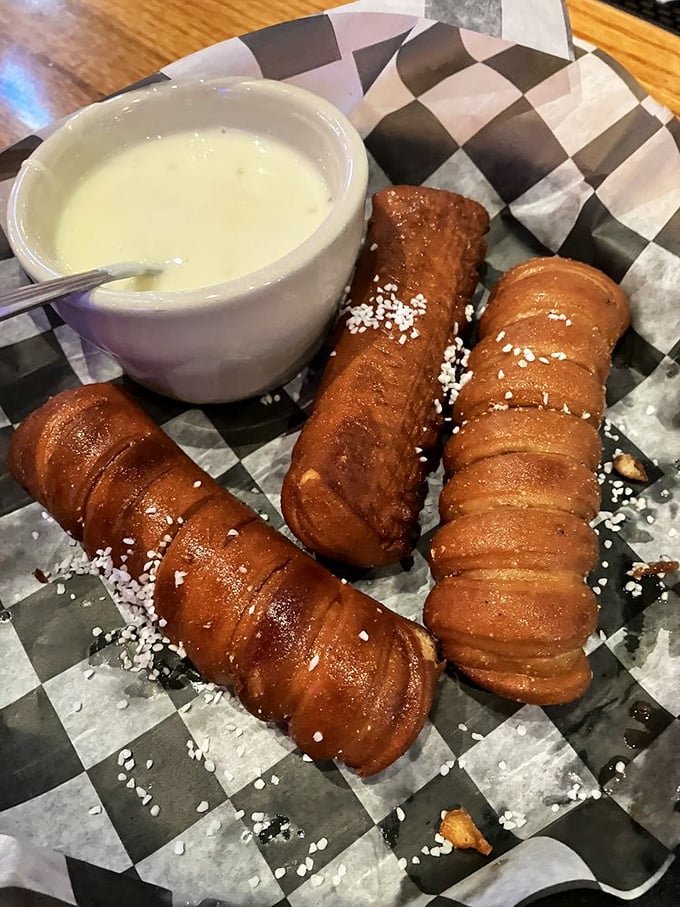 These pretzel breadsticks aren't just appetizers—they're dunkable vessels of joy waiting for their cheese sauce baptism.