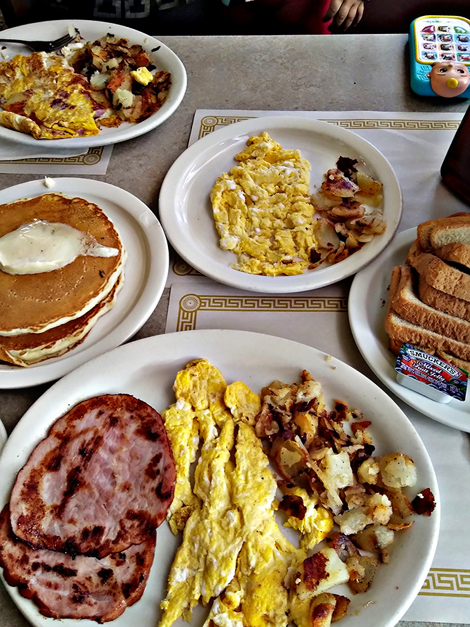 The breakfast spread that launches a thousand napkins. That stack of pancakes is the Everest of the table's landscape.