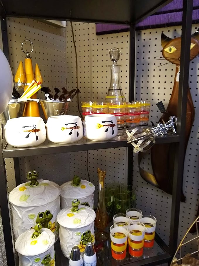 Whimsical ceramic canisters with frog motifs sit alongside colorful glassware – kitsch has never looked so tempting or collectible.