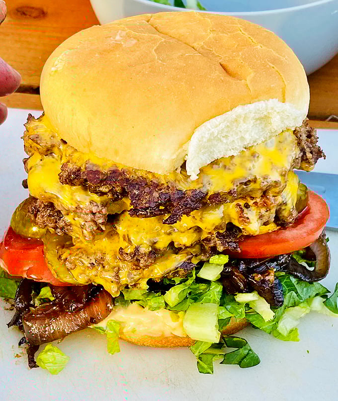 This triple cheeseburger isn't just a meal – it's a monument to American excess that somehow feels completely necessary.