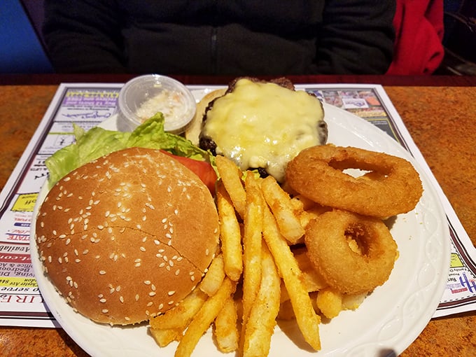 The classic American trifecta: a perfectly grilled burger, golden fries, and crispy onion rings—comfort food that speaks a universal language.