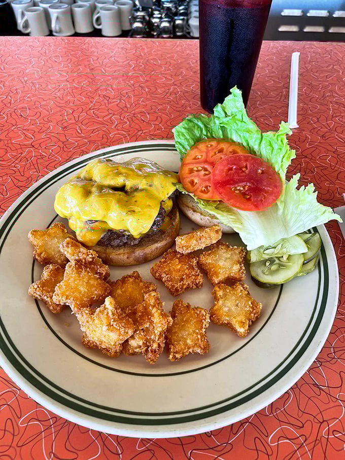 A burger that means business, with melted cheese cascading down the sides and crispy nuggets of fried goodness standing by for backup.