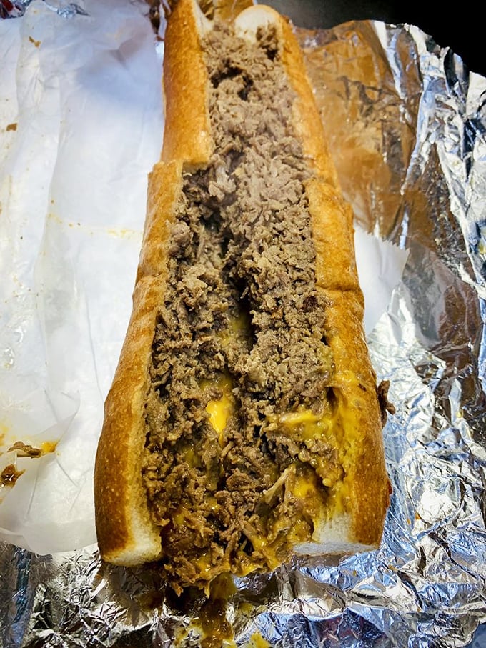 The classic cheesesteak with Whiz—molten gold cascading through seasoned beef. This isn't just a sandwich; it's Philadelphia's soul between two pieces of bread.