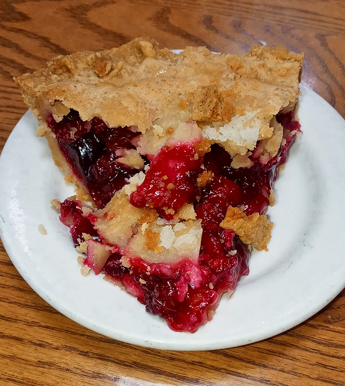 Berry filling erupts from flaky crust like nature's lava—this slice of cherry pie demands to be savored, not just eaten.