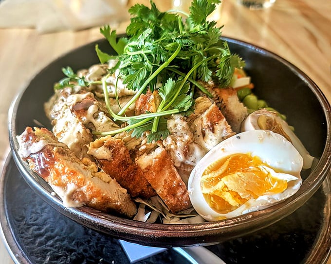 Not just chicken and rice—it's a bowl of comfort crowned with a perfectly soft-boiled egg that's basically nature's sauce packet.