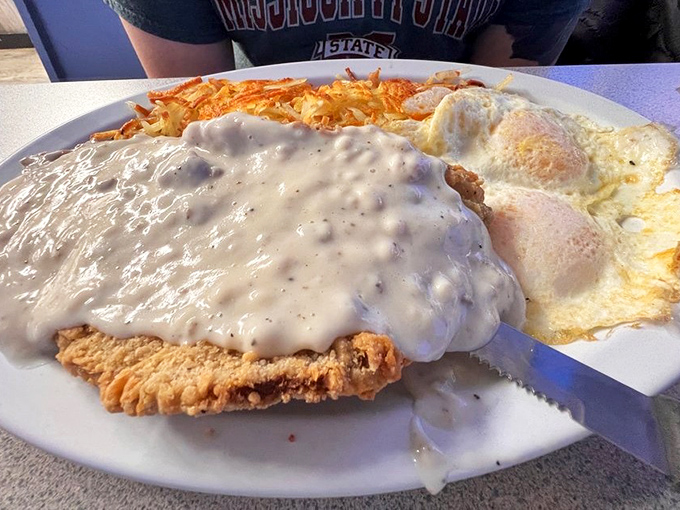 Chicken fried steak smothered in gravy with eggs standing by. When your breakfast needs its own area code, you know you're doing something right.