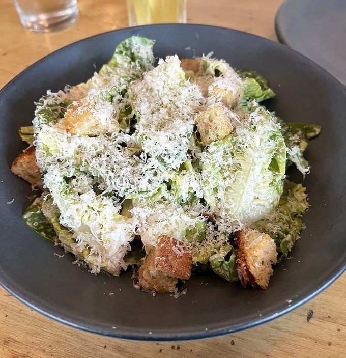 A Caesar salad that Julius himself would approve – crisp romaine baptized in parmesan snowfall and punctuated with rustic croutons.