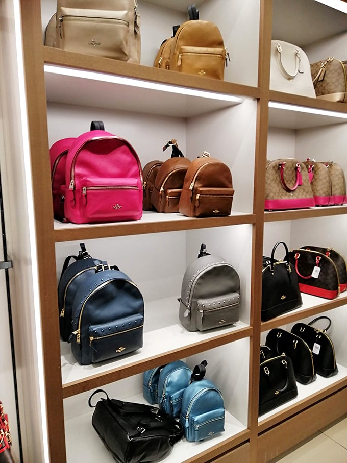 Coach backpacks and handbags arranged like fine art. Your wallet may be getting lighter, but your style is about to get heavier.