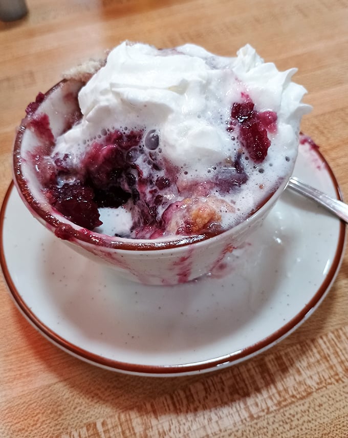 Berry cobbler that tastes like summer vacation at grandma's house, complete with melting ice cream creating sweet little rivers of deliciousness.