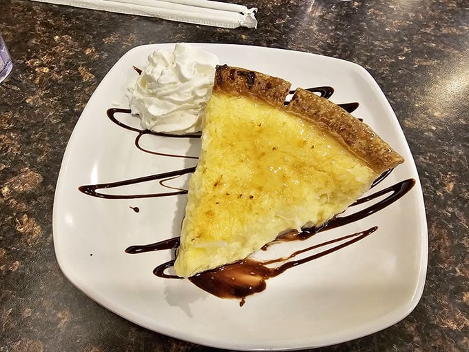 Custard pie with a golden top that whispers "I was made this morning." The whipped cream zigzag is pure diner artistry.