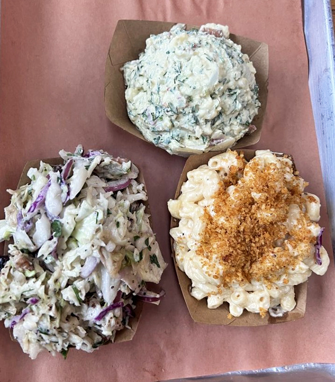 The holy trinity of barbecue sides: creamy mac and cheese, tangy slaw, and potato salad that doesn't come from anyone's aunt's recipe card – it's better.