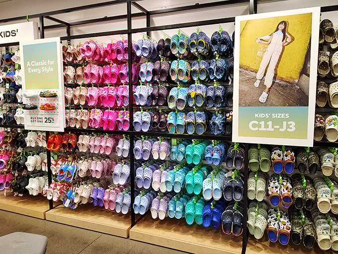 The Crocs rainbow wall—where fashion practicality meets foot comfort in a dazzling display that makes you think, "Maybe I DO need turquoise clogs!"