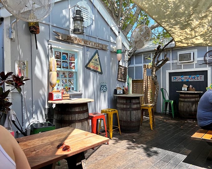 A slice of Old Florida charm under the shade sails—where barrel tables and colorful stools create the perfect seafood sanctuary.