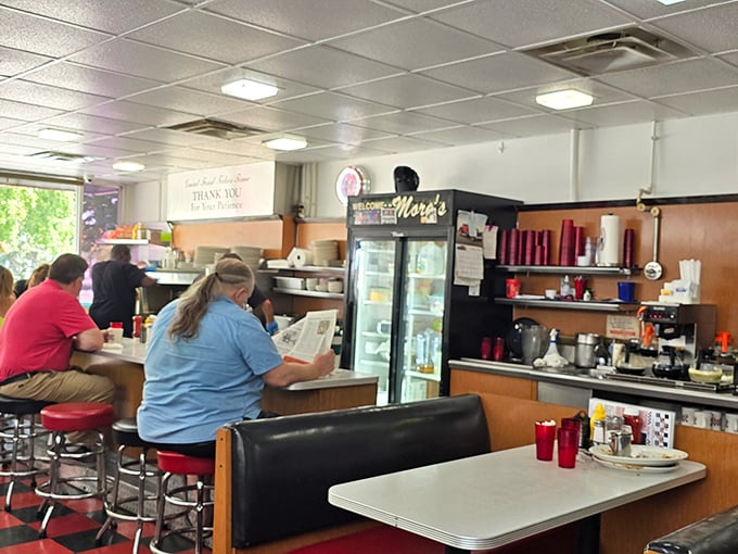 The counter view—where regulars find their second home and the rhythm of spoons stirring coffee creates the soundtrack to morning in Iowa.