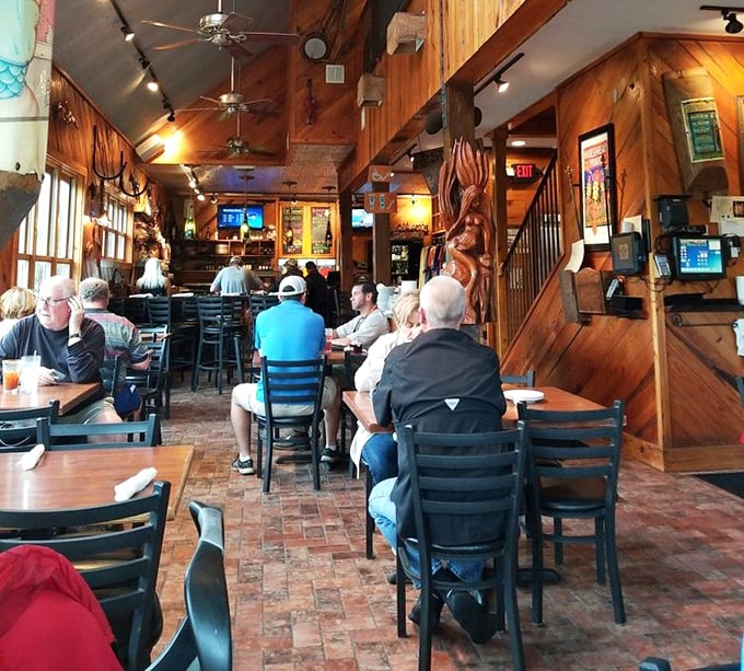 The dining room hums with the satisfied murmurs of patrons who've discovered Florida's worst-kept seafood secret. Those smiles aren't just politeness—they're testimonials.