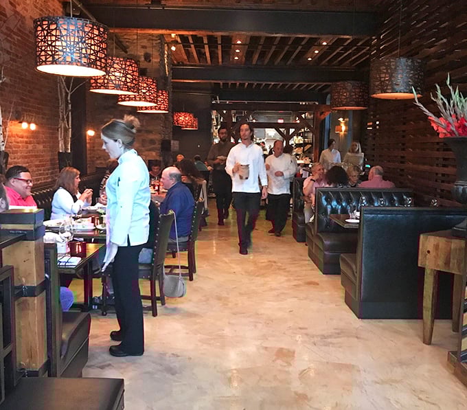 The ballet of fine dining in progress—servers gliding between tables while diners engage in that universal ritual of falling in love with their food.