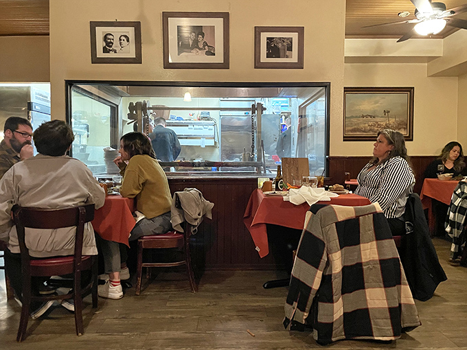 Diners gather around tables facing the kitchen window—dinner and a show where the star is always that magnificent oak-fired grill.
