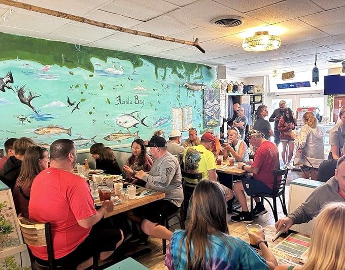 A packed house of happy diners beneath that iconic fish mural—proof that finding good food is the universal language of travel.