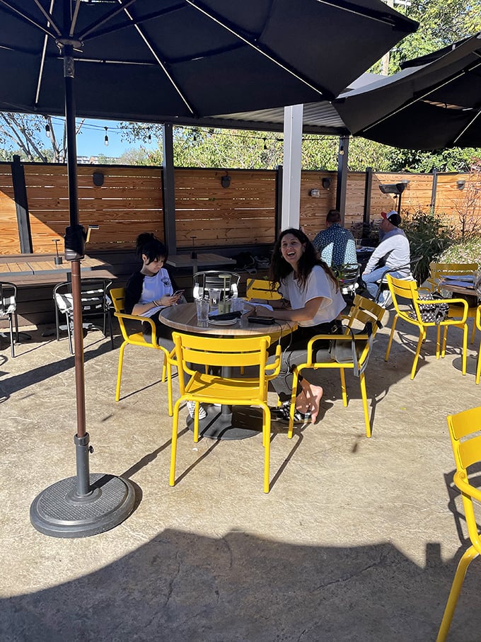 The sunny patio with its cheerful yellow chairs invites lingering. This is where "just one more drink" turns into "should we split a dessert?"