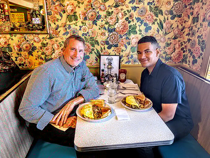 Two happy diners enjoying the fruits of Fred's kitchen labor—those plates of breakfast goodness are worth smiling about.