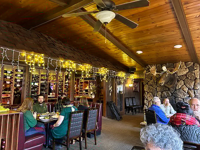 Where taxidermy meets taste—the dining room's warm wood tones and stone fireplace create that "welcome home" feeling even on your first visit.