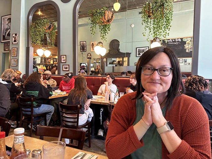 The dining room buzzes with the energy of satisfied customers. Plants cascade from above while conversations and coffee cups flow freely below.