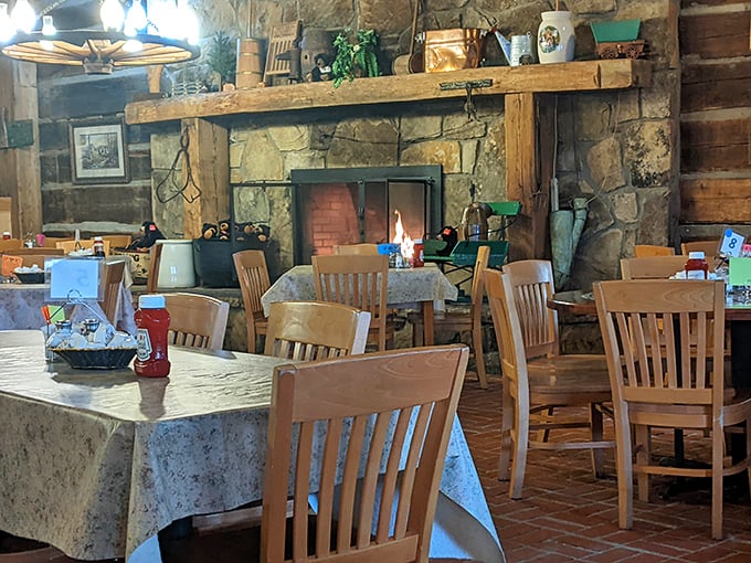 That stone fireplace isn't just for show—it's the heart of this dining room where generations of families have gathered to fuel up before mountain adventures.