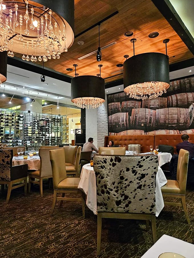 Wine barrels adorn the walls while crystal chandeliers dangle overhead – rustic meets refined in this thoughtfully designed dining space.