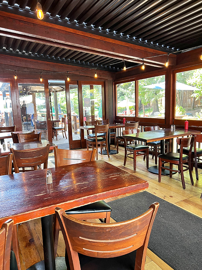 String lights, wooden beams, and picture windows bringing nature indoors—dining here feels like being in a treehouse for grown-ups.