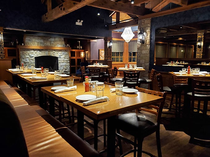 Stone fireplace, wooden tables, and comfortable seating—this dining area feels like the living room of that friend who really knows how to cook.